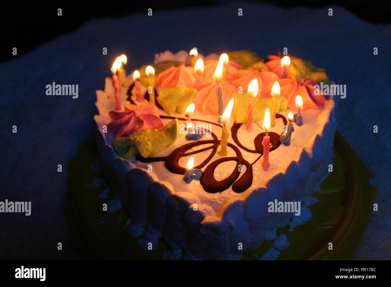 airy cream cake in shape of the heart with candles for birthday ...