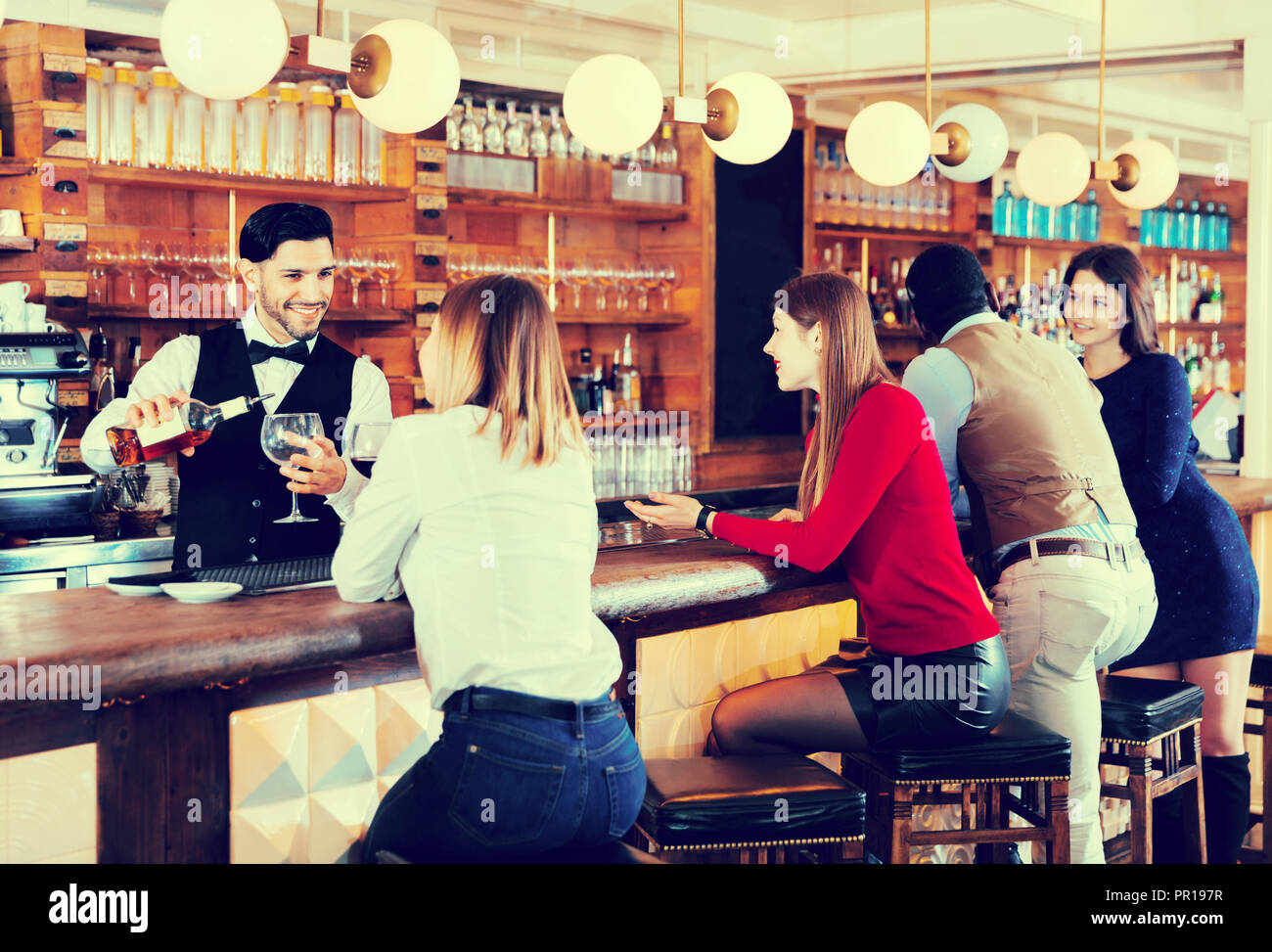 Portrait of positive smiling barman and glad people who are standing ...