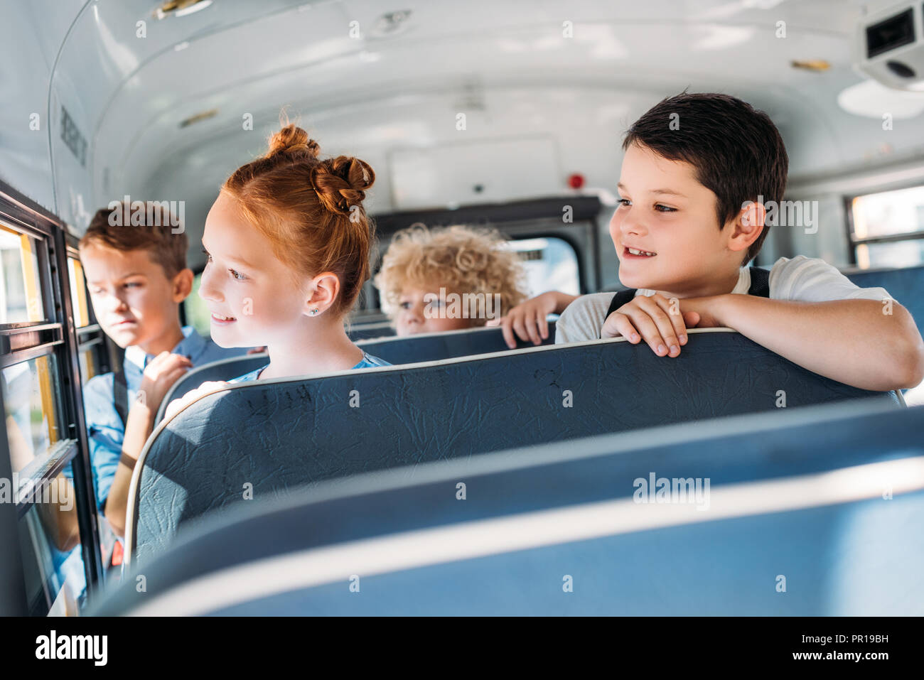 group of pupils riding on school bus and looking through window Stock ...