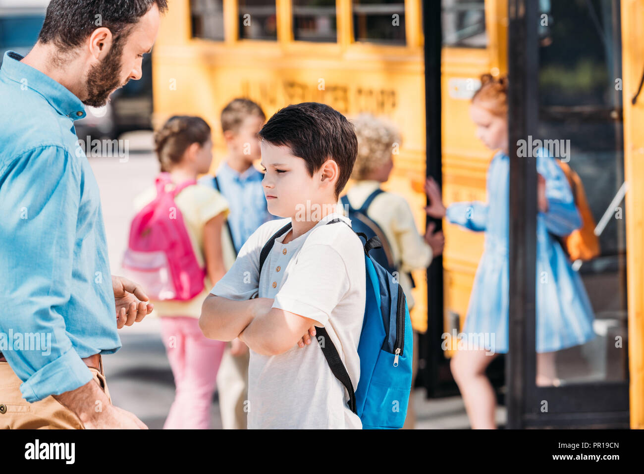 angry father disciplines his son in front of school bus Stock Photo - Alamy