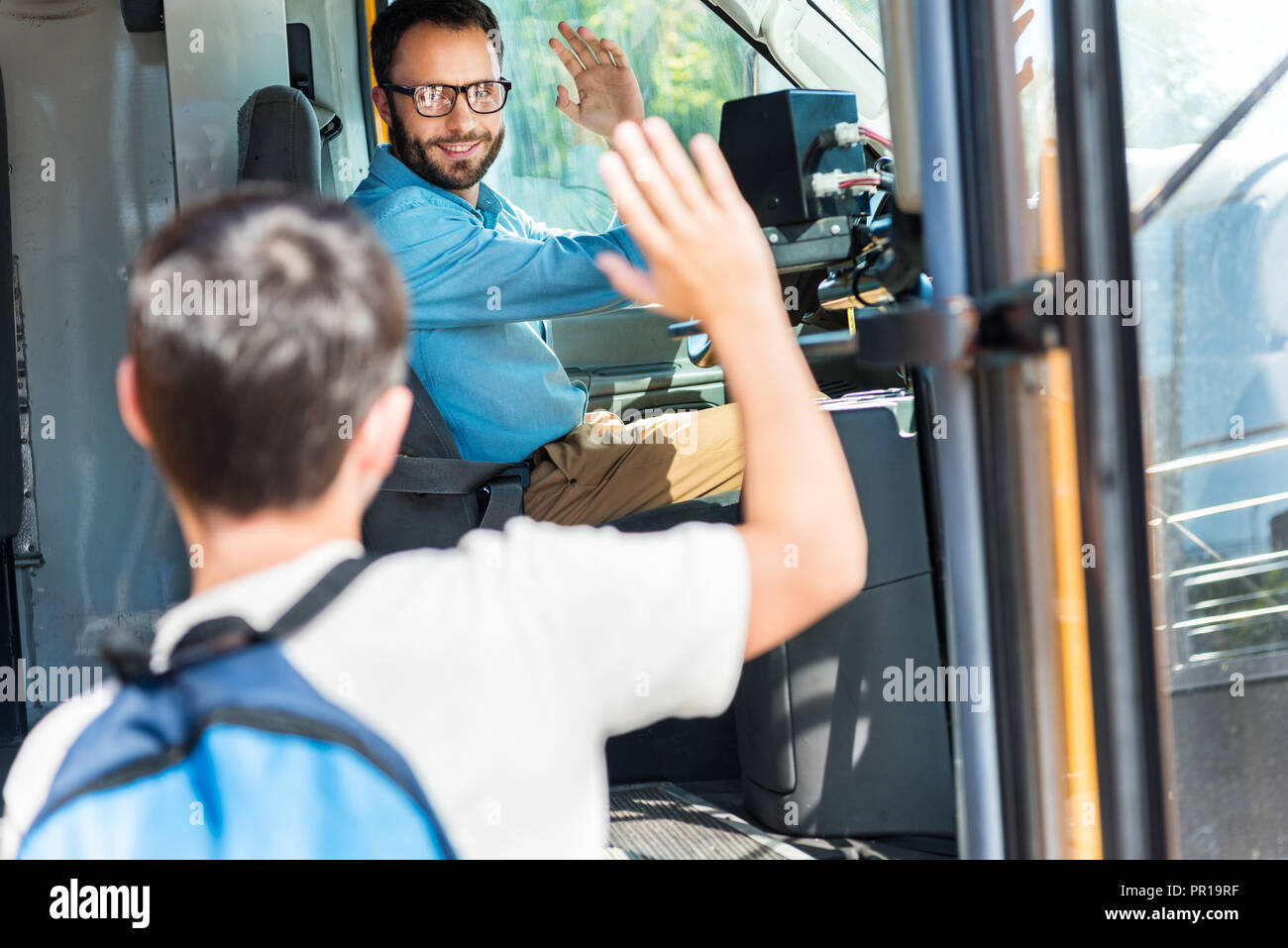 handsome smiling bus driver greeting schoolboy who entering bus Stock ...