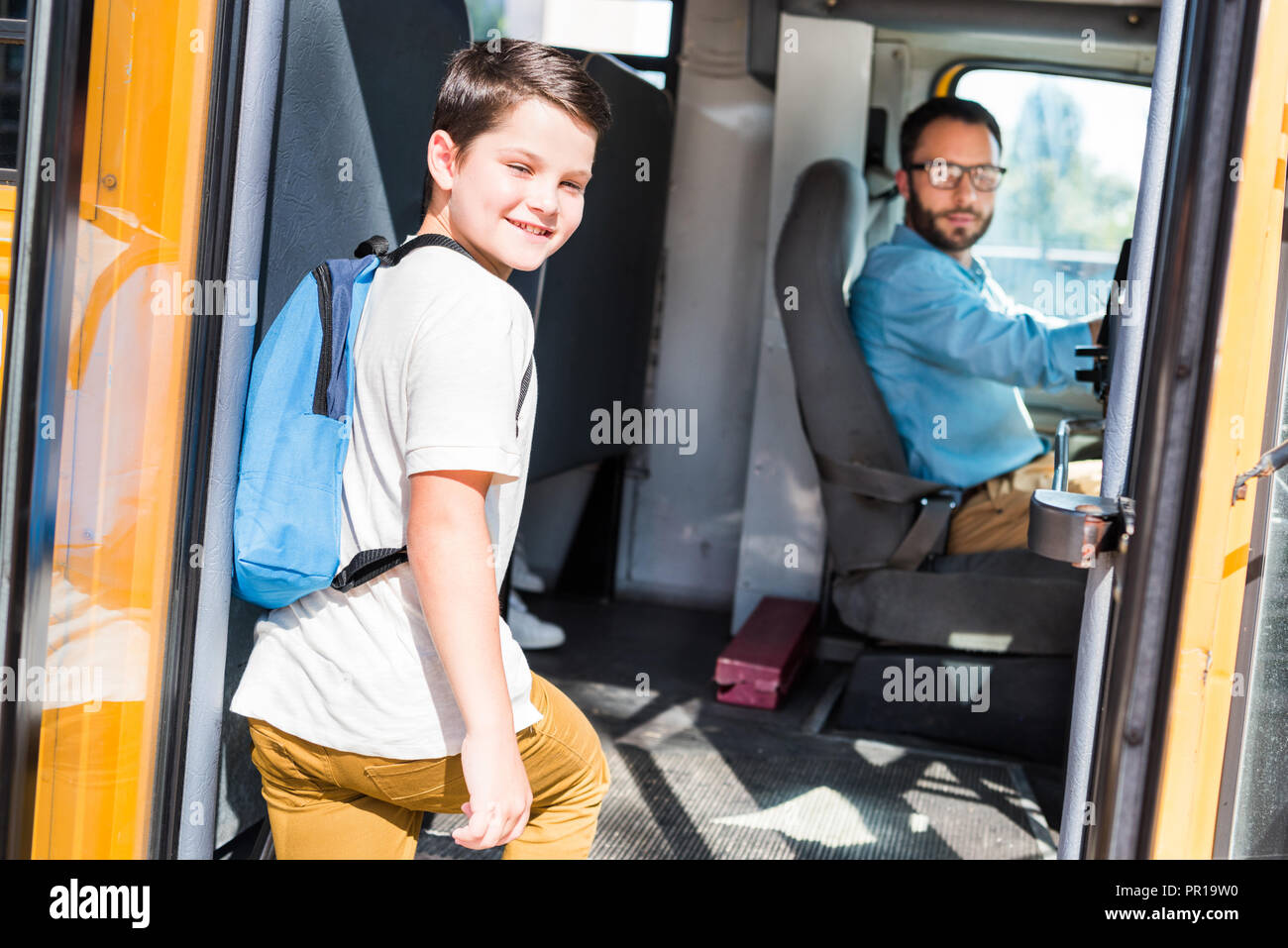 handsome school bus driver and schoolboy looking at camera Stock Photo ...
