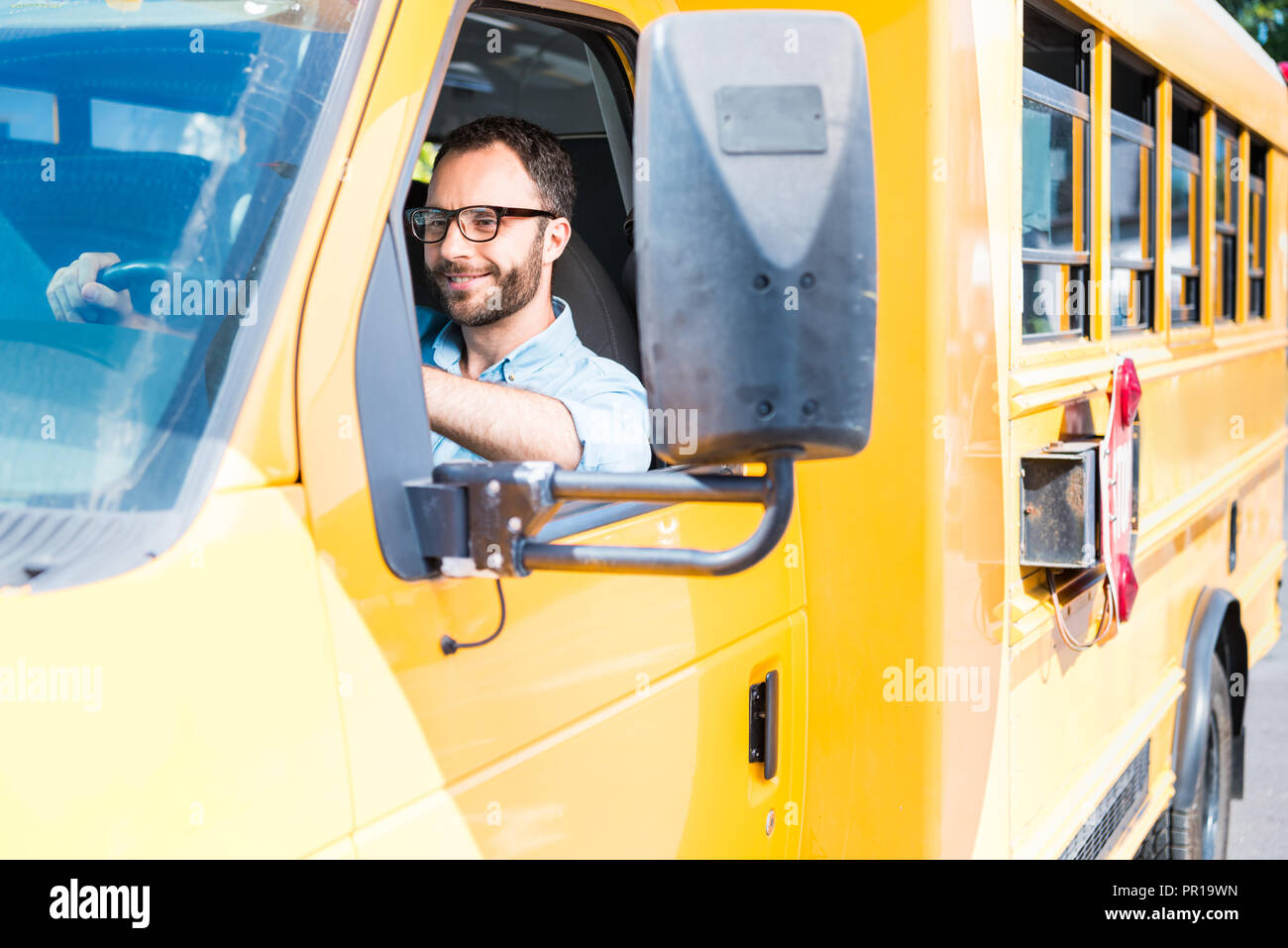 handsome school bus driver smiling and driving Stock Photo - Alamy