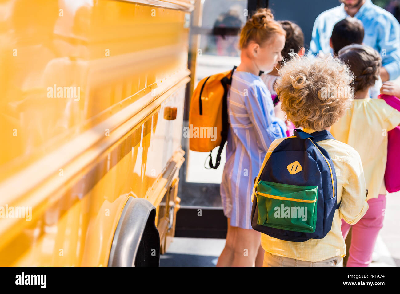 rear view of group of pupils near school bus Stock Photo - Alamy