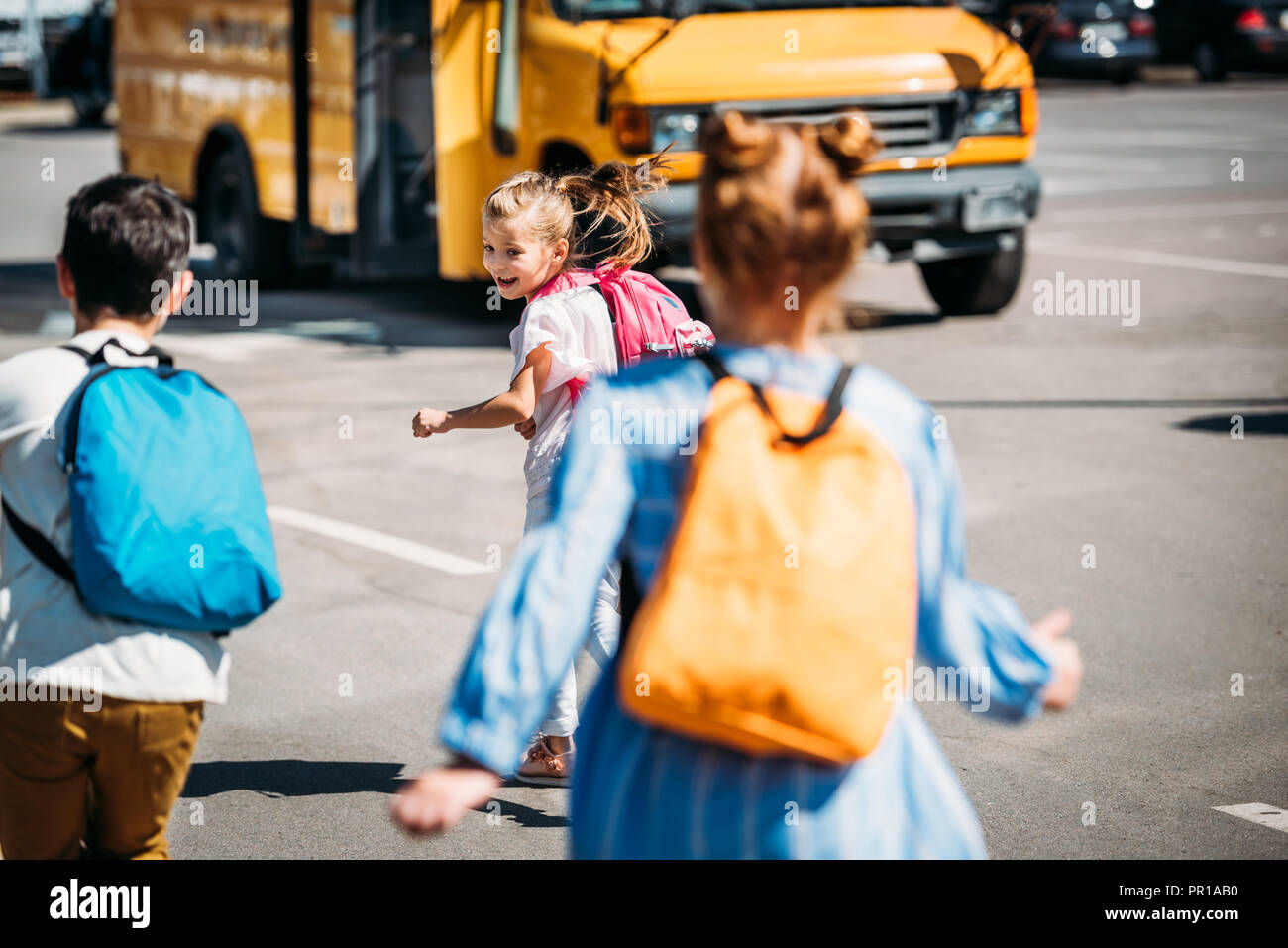 rear view of happy schoolchildren running to school bus Stock Photo - Alamy