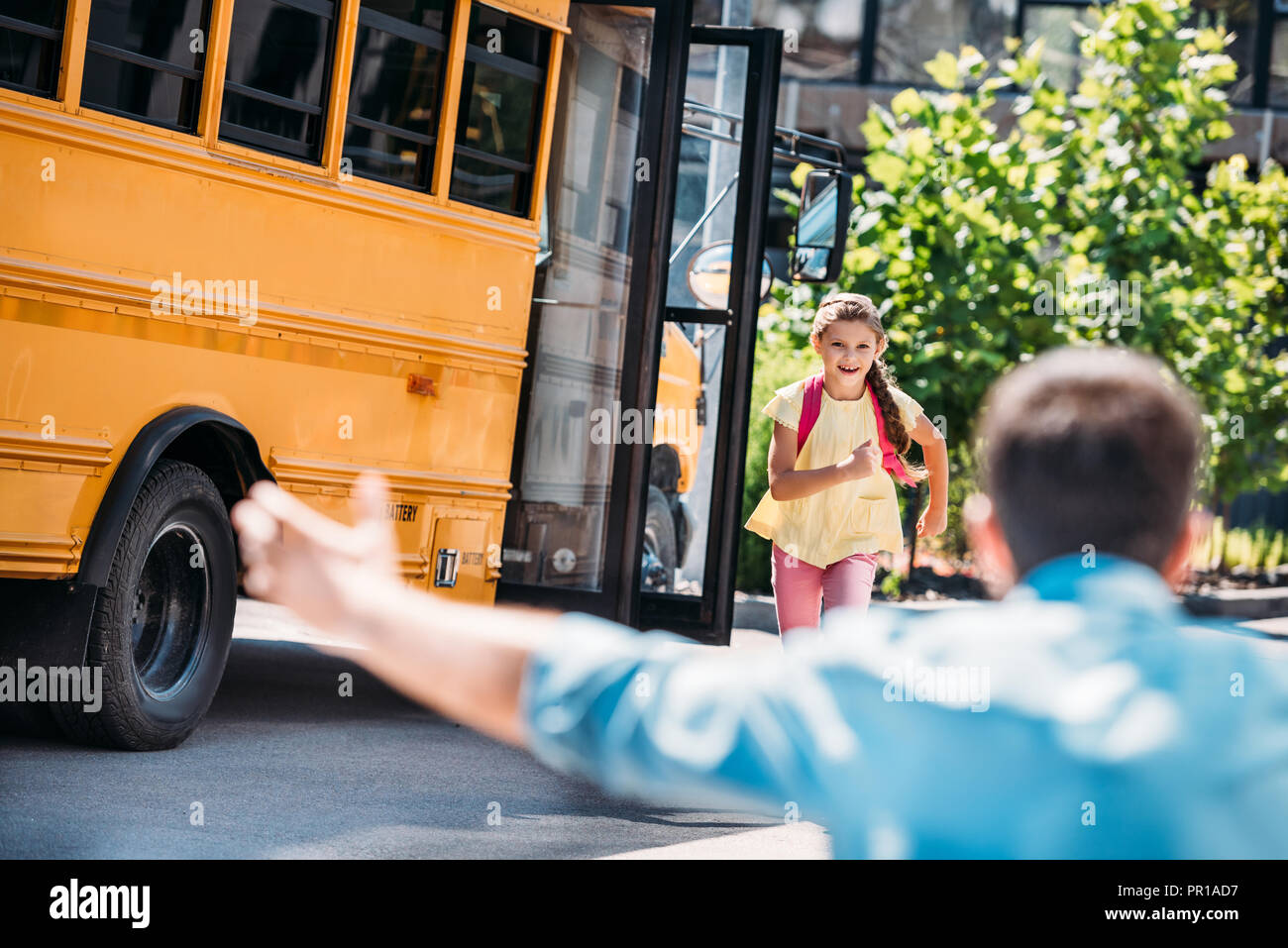 rear view of father with open arms waiting for adorable little daughter ...