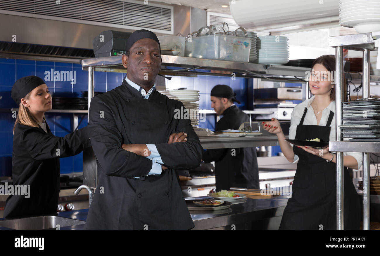 Confident African American chef of restaurant posing with arms crossed ...