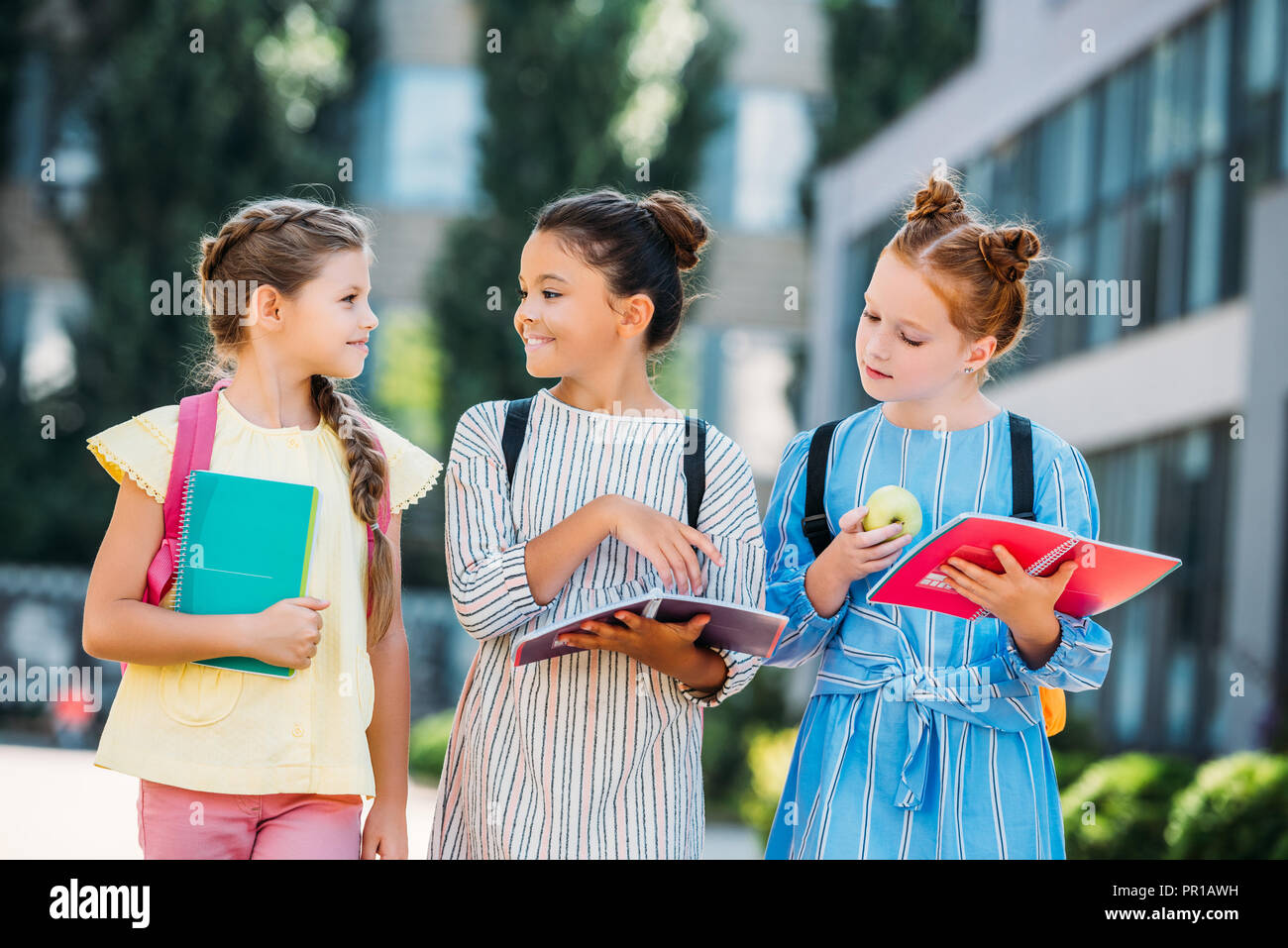 group of beautiful schoolgirls with notebooks spending time together ...