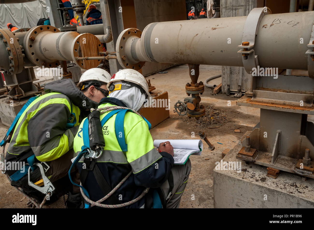 Worker on construction site checking documents Stock Photo - Alamy