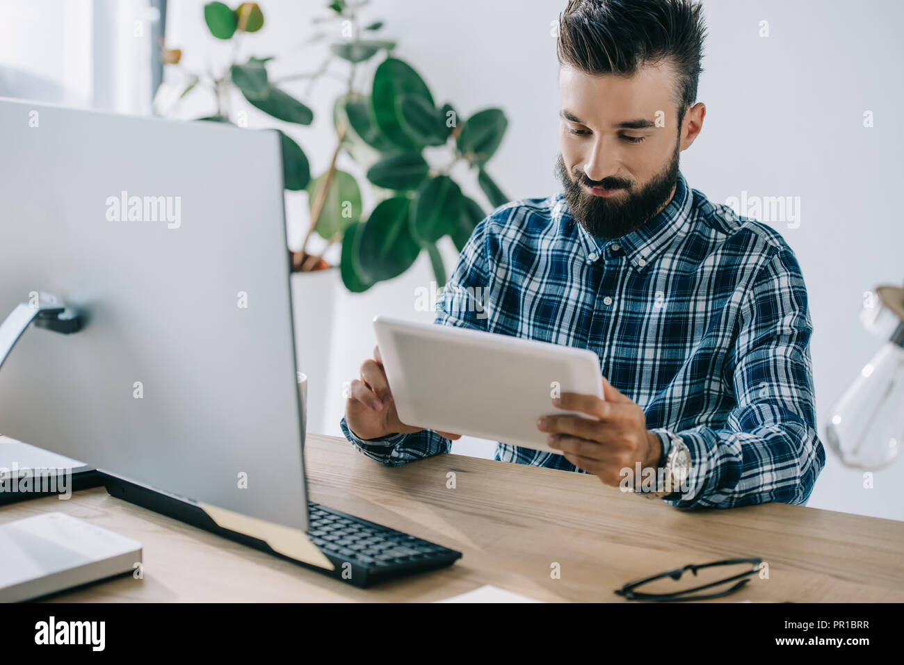 handsome young man using tablet at workplace Stock Photo - Alamy