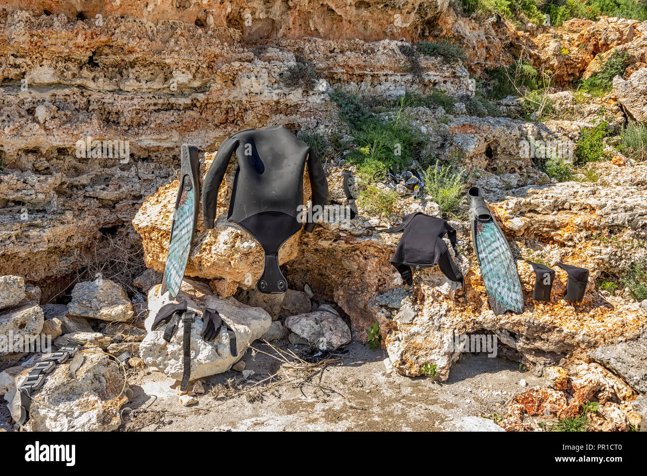 Wet parts of diving equipment drying out in the sun on the rocks Stock ...