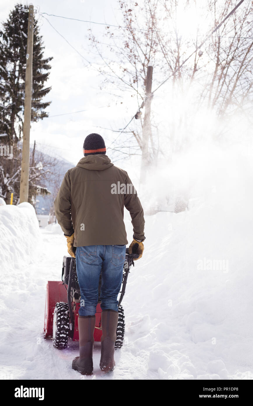 Man using snow blower machine in snowy region Stock Photo - Alamy