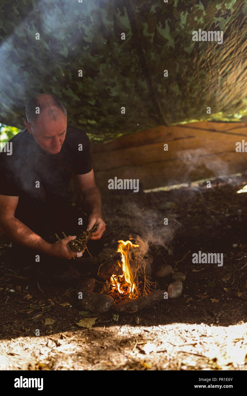 Man lighting fire at boot camp Stock Photo - Alamy