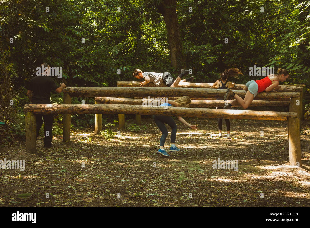 Fit people training over obstacle course Stock Photo - Alamy