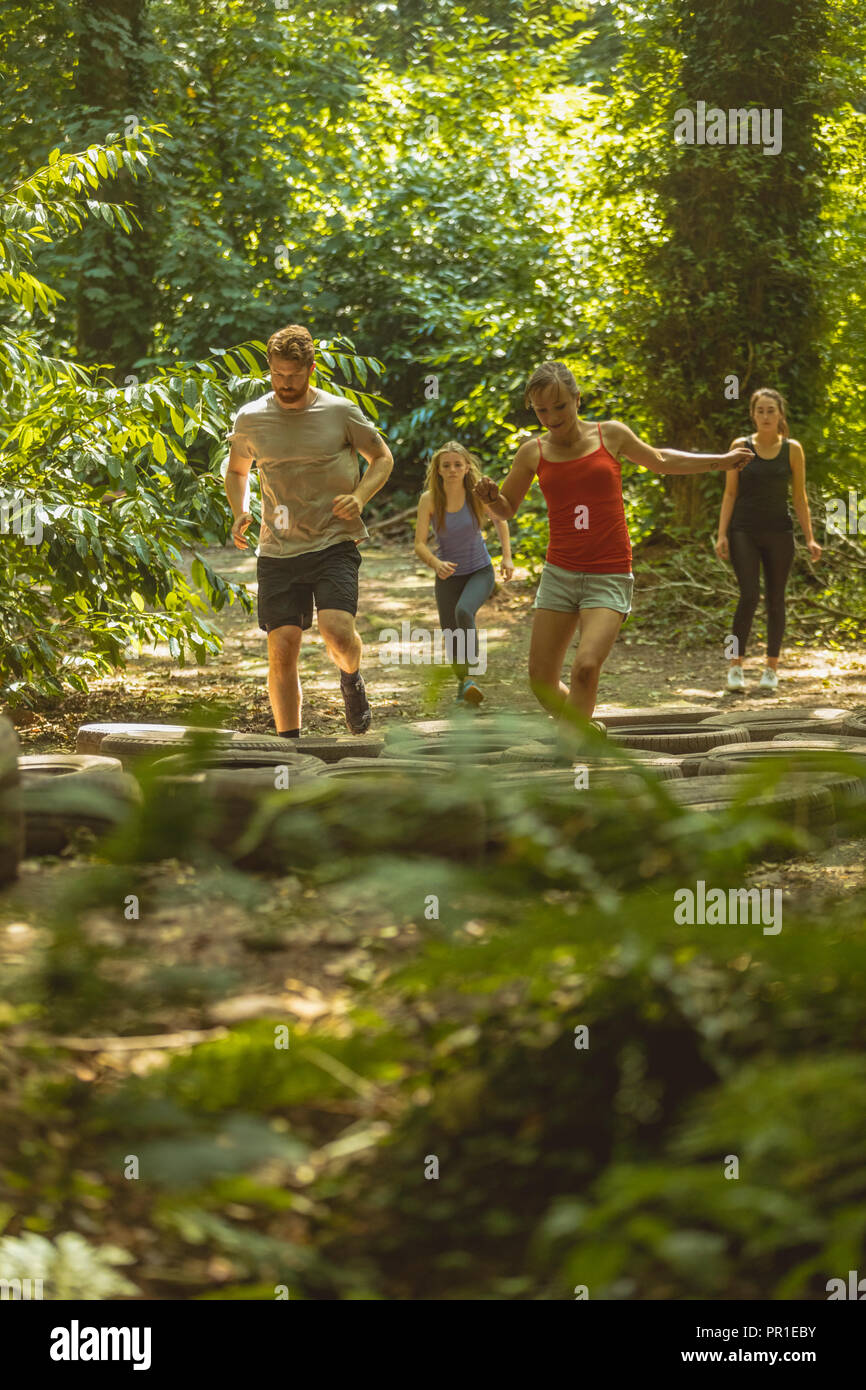 Fit people training over tyre obstacle course Stock Photo - Alamy