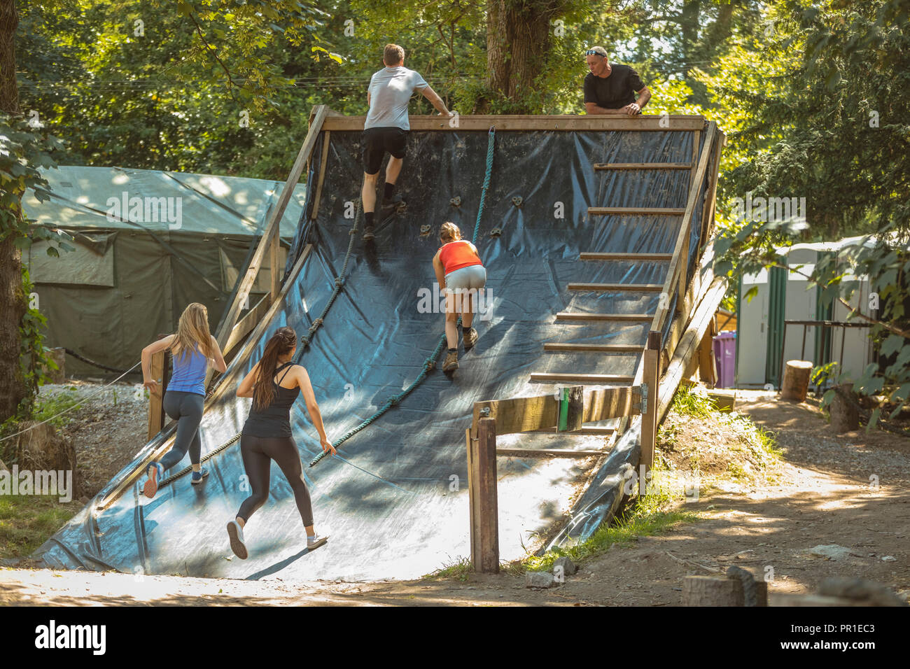 Fit people training over obstacle course Stock Photo - Alamy