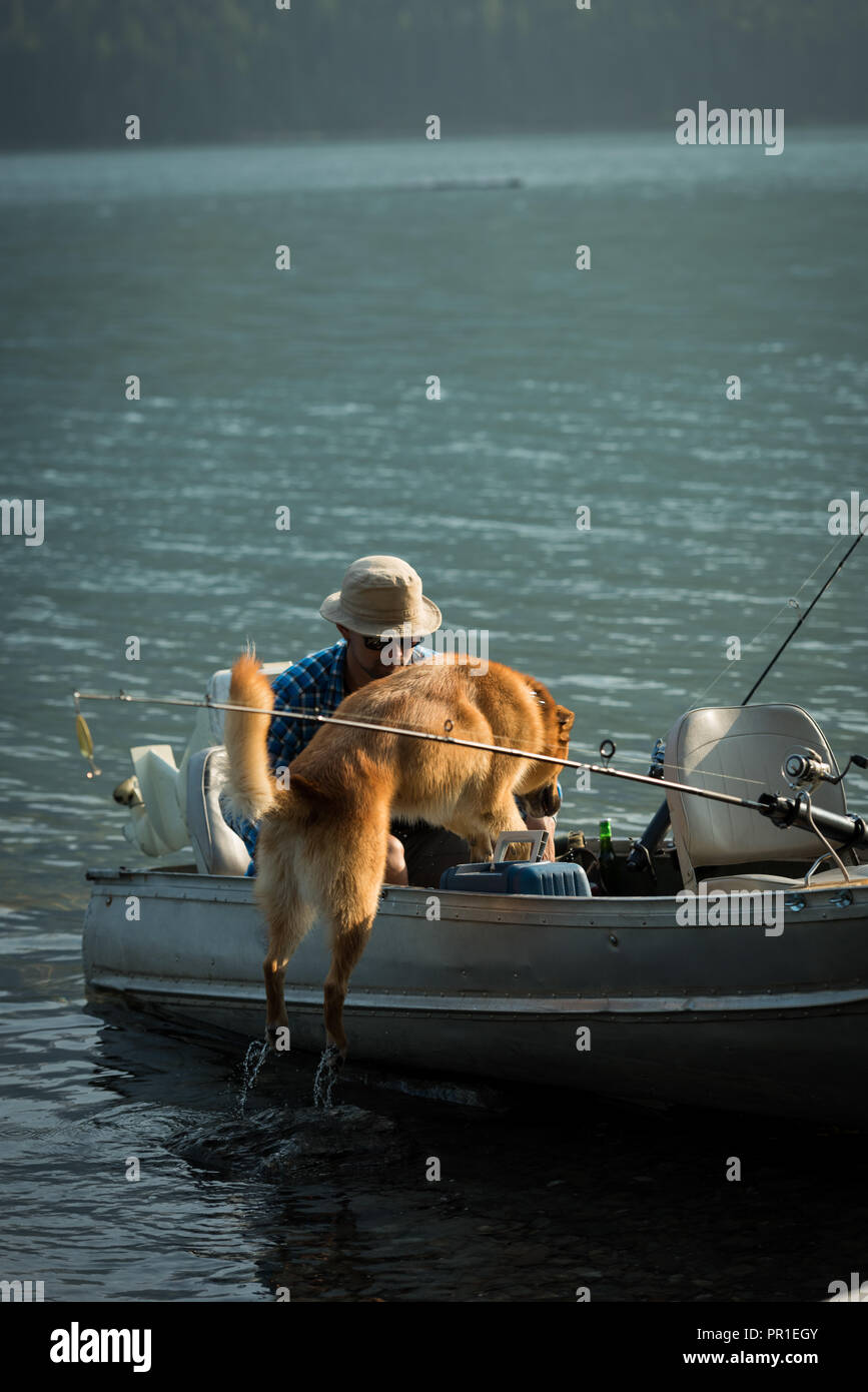 Dog with fisherman on a boat Stock Photo - Alamy