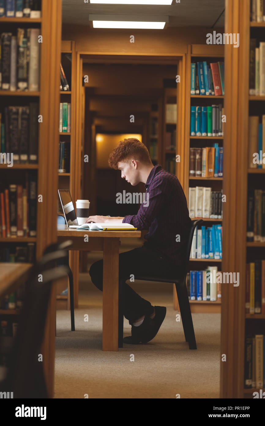 College student using laptop in library Stock Photo - Alamy