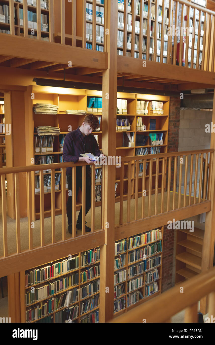 College student reading a book in library Stock Photo - Alamy