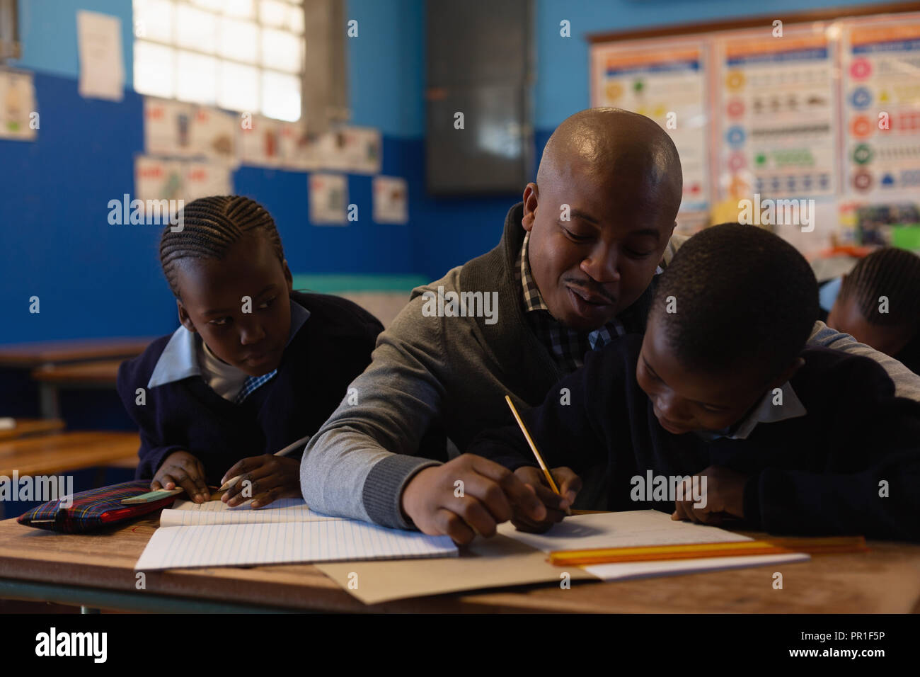 Male teacher teaching students in the classroom Stock Photo - Alamy