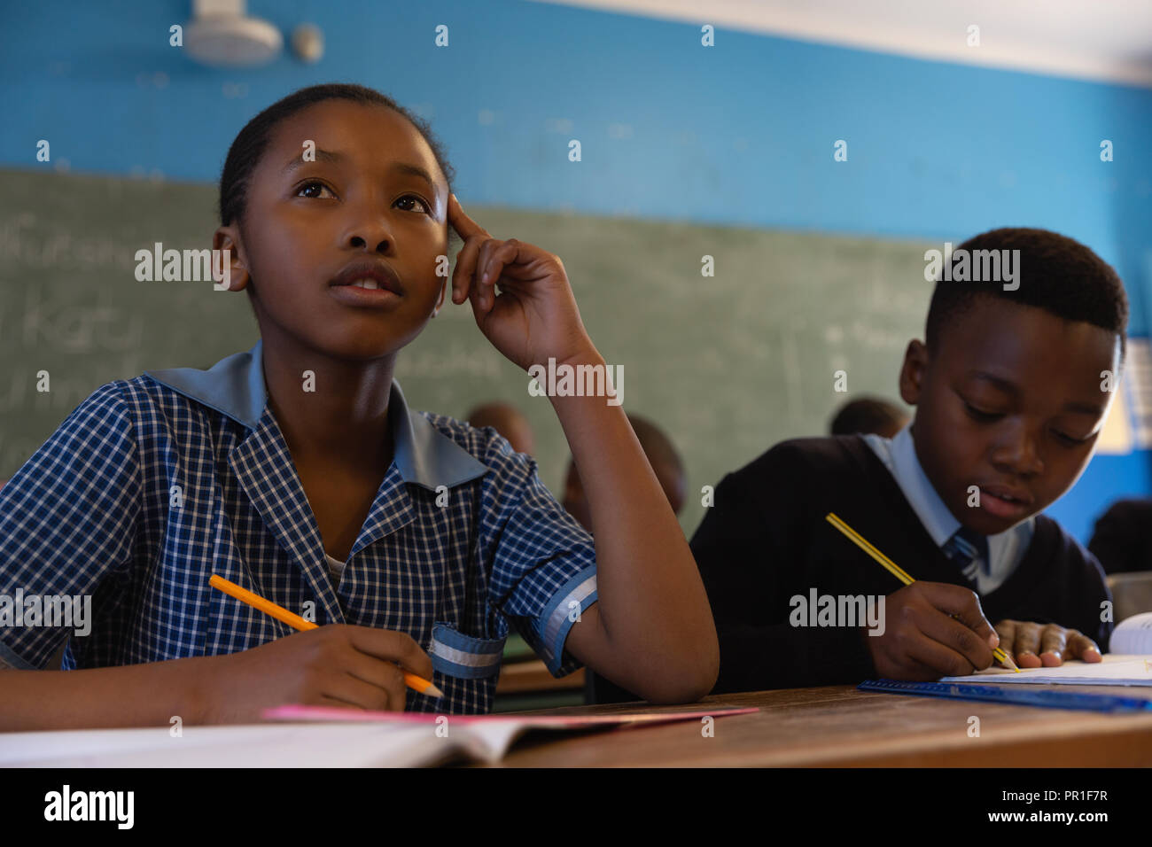 Schoolkids holding sketch pens in classroom Stock Photo - Alamy