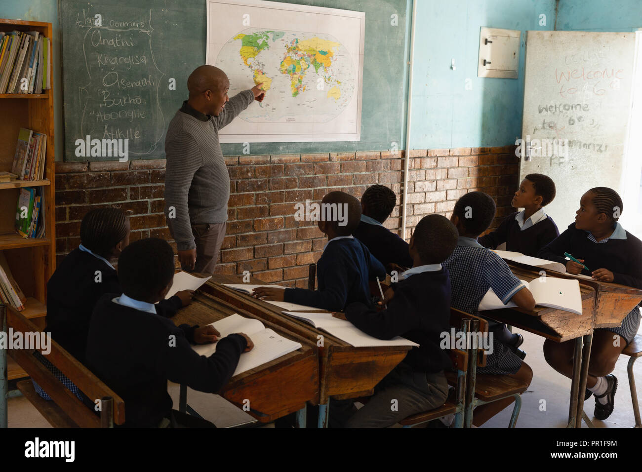 Male teacher teaching students in the classroom Stock Photo - Alamy