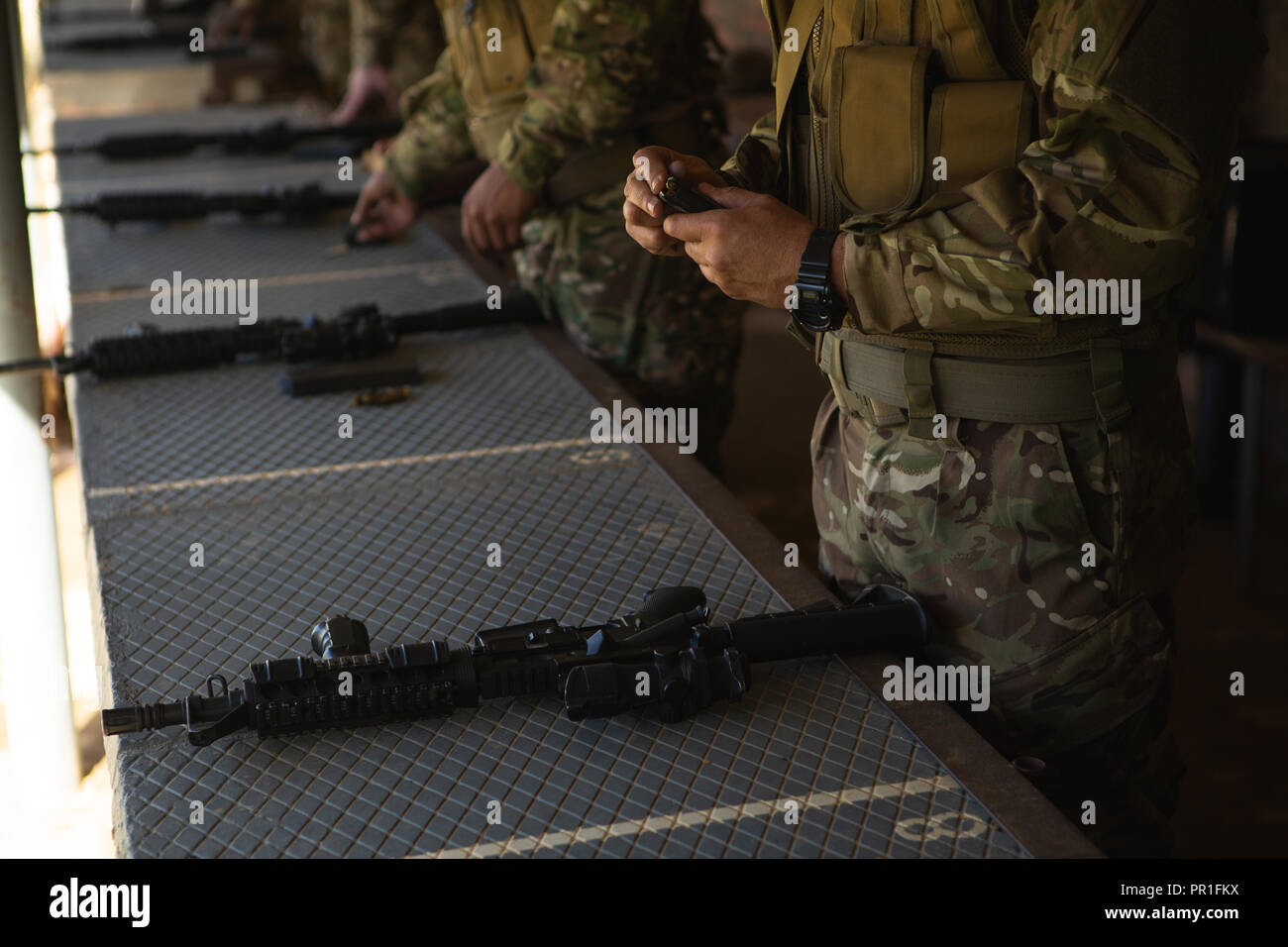 Military soldiers loading bullets in magazine Stock Photo - Alamy