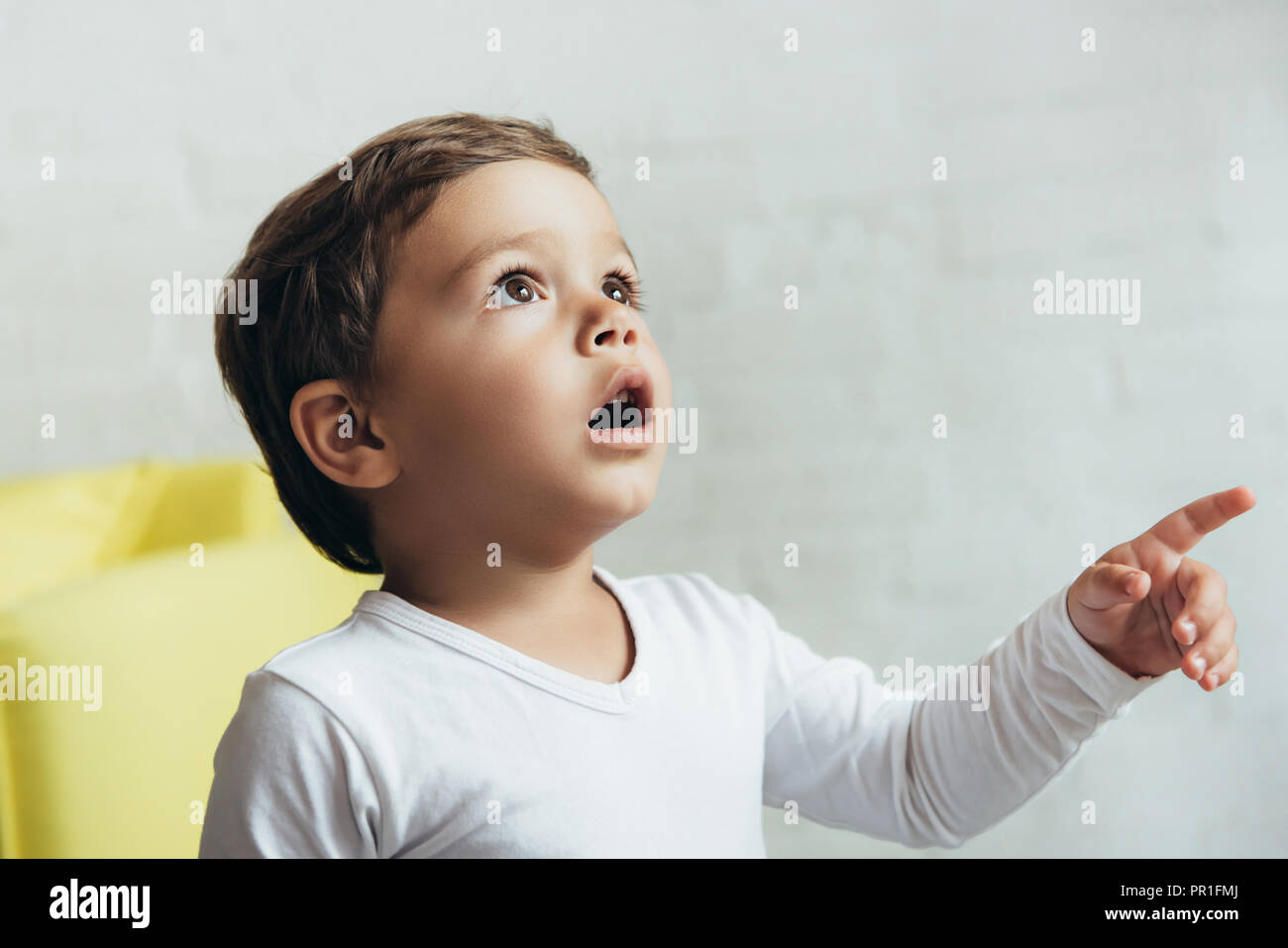 portrait of little shocked boy pointing and looking up Stock Photo - Alamy