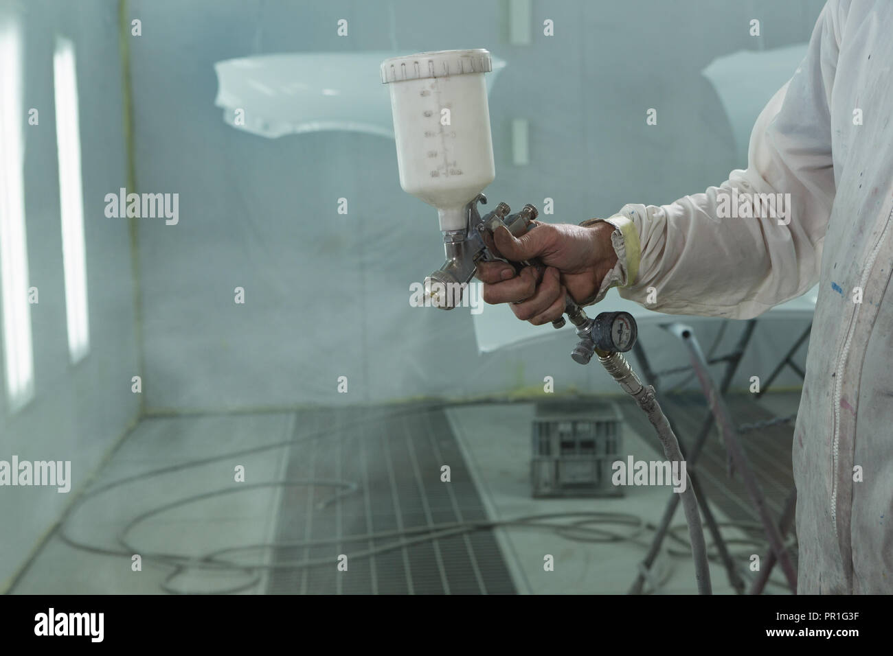 Male mechanic using spray paint Stock Photo - Alamy