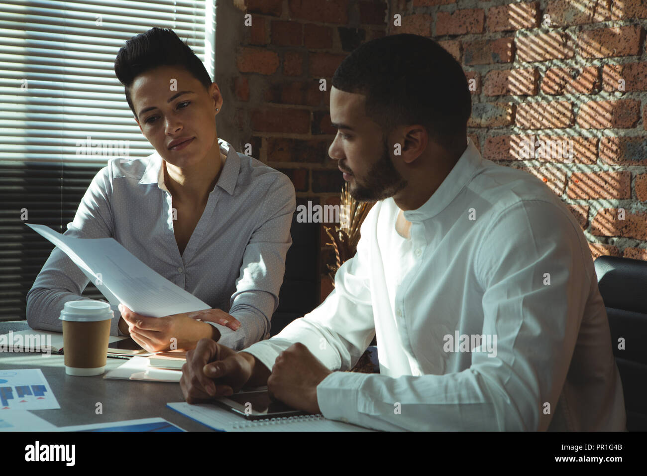 Executives discussing over document in conference room Stock Photo - Alamy