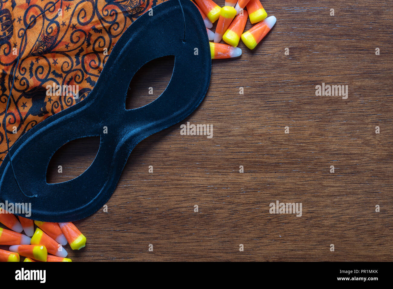 orange and black Halloween scarf and mask with candy corn on a wood ...