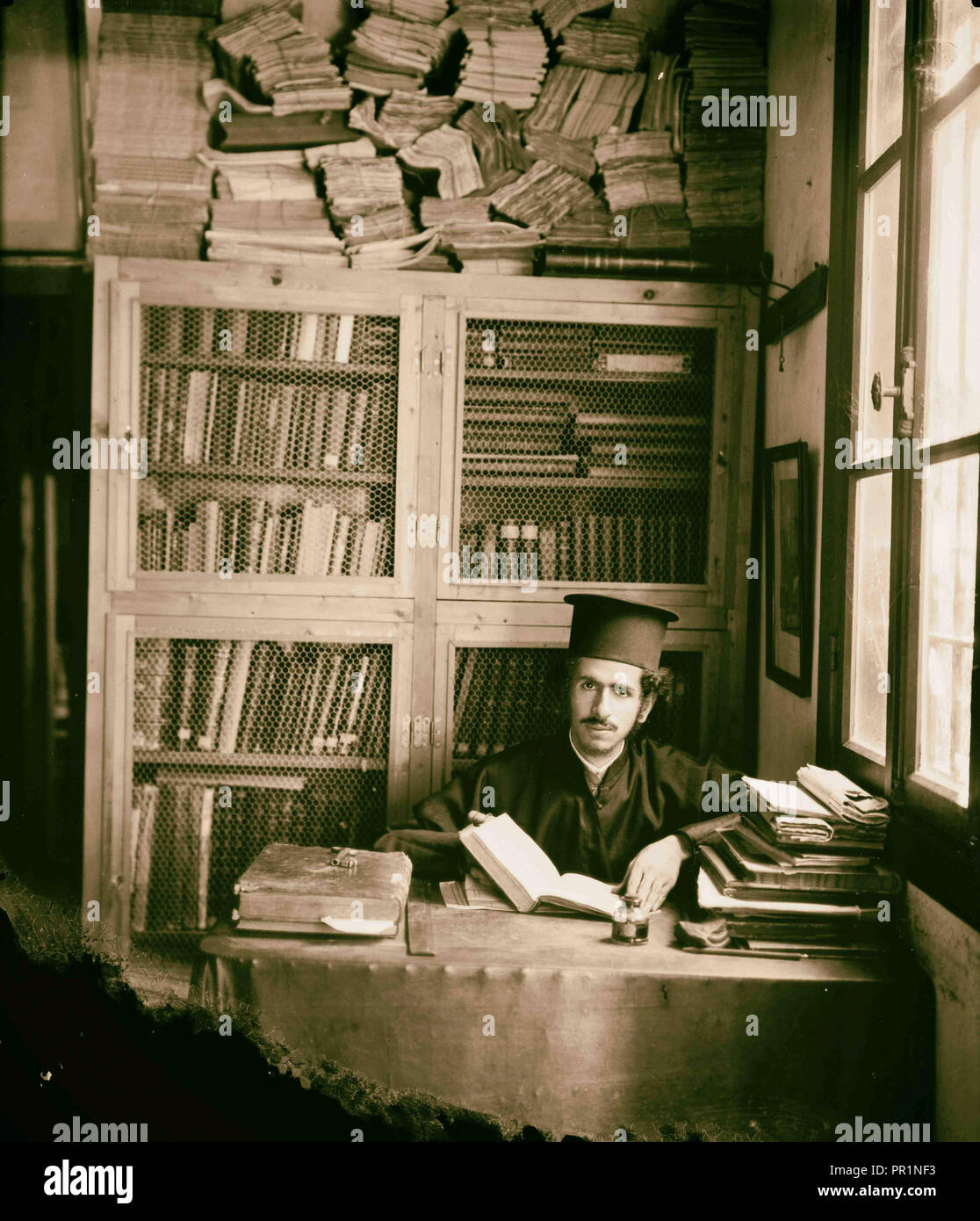 Greek Orthodox monk in a convent library presumably in Jerusalem. 1898 ...