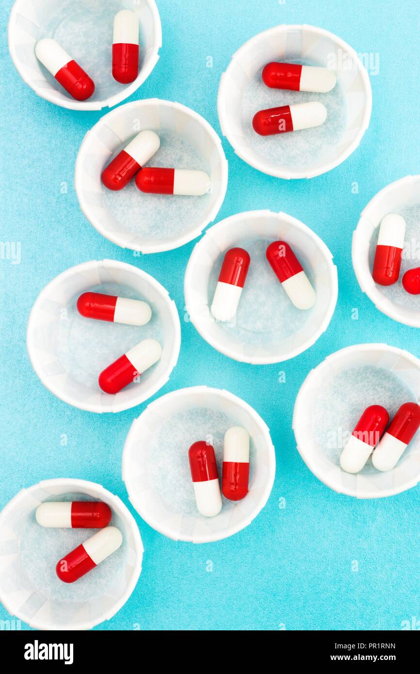 Paper medicine pots with red and white drug capsules Stock Photo - Alamy