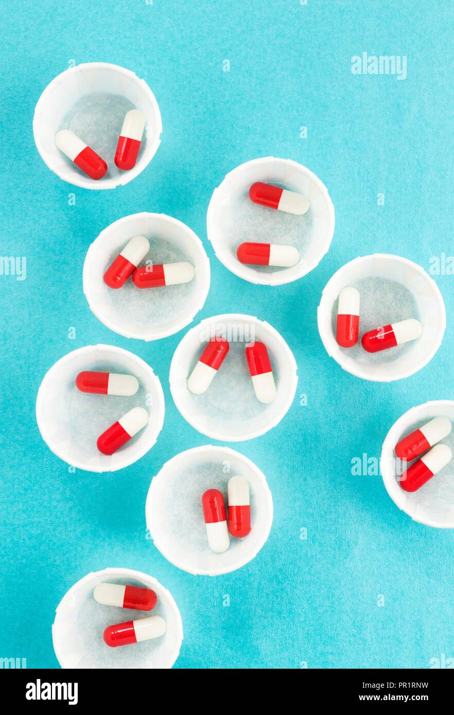 Paper medicine pots with red and white drug capsules Stock Photo - Alamy