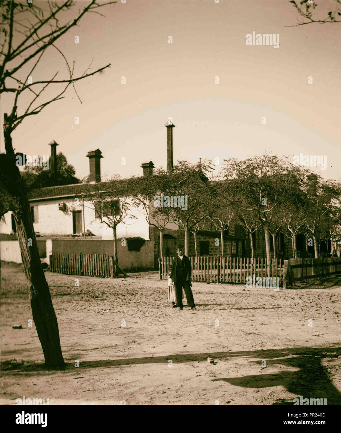 Mikweh. Boy and shy girl in front of building American Colony ...