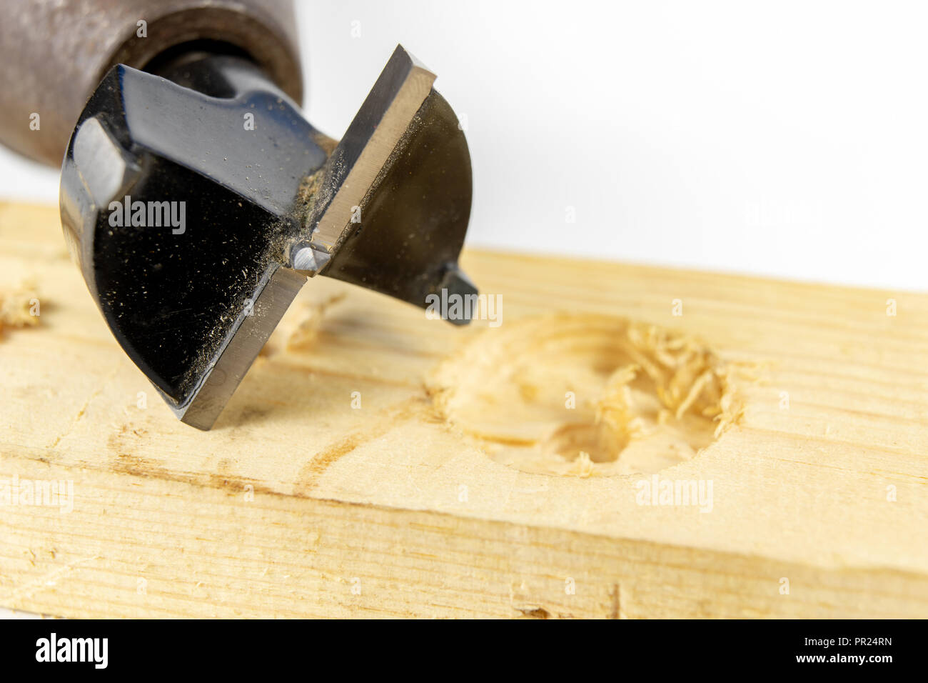 Drilling holes with a wood drill in a workshop. Joinery works performed ...