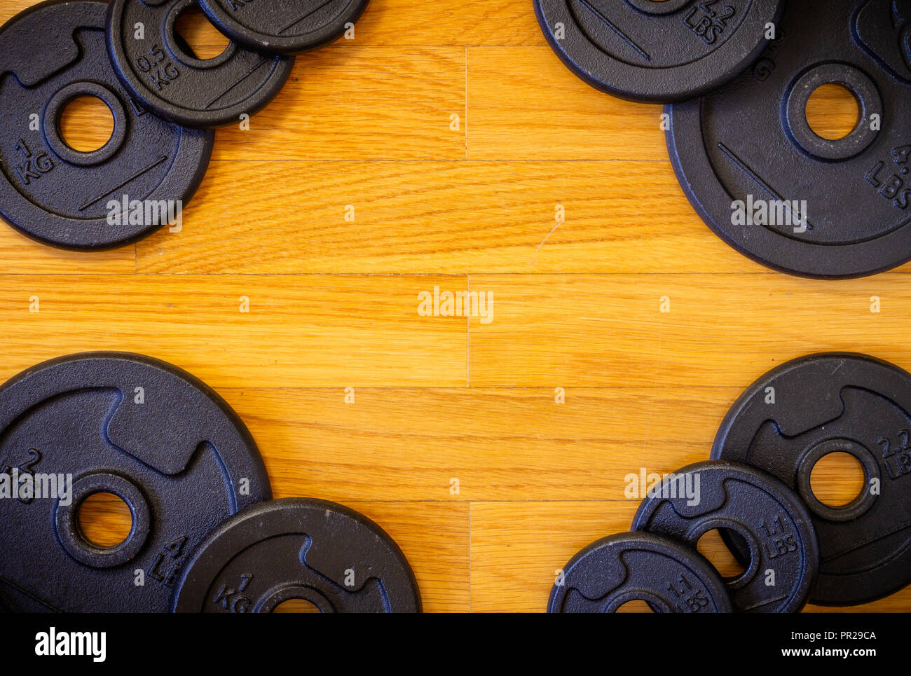 A wooden background with a set of gym equipment consisting of various ...