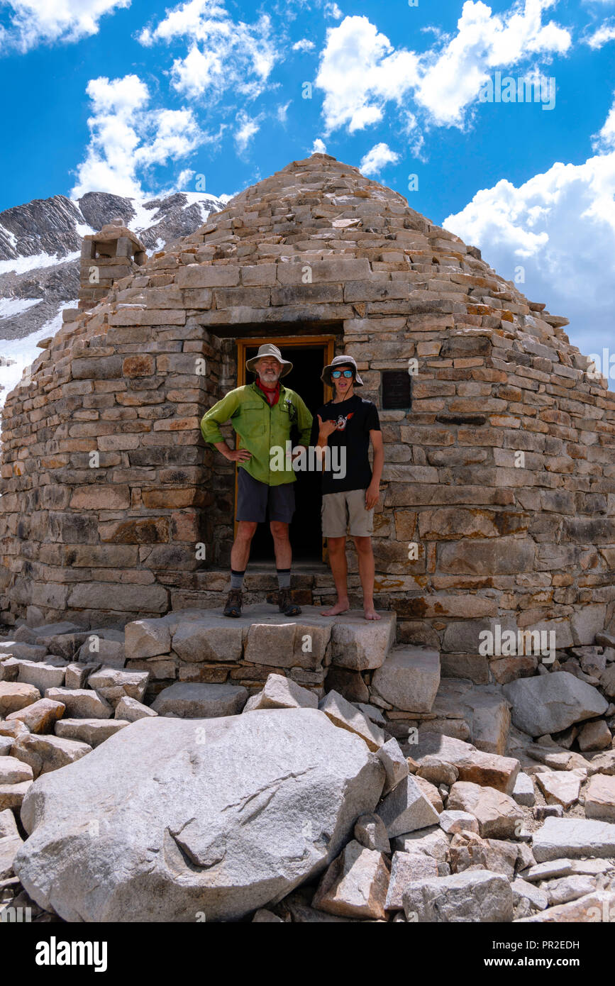 Father and son backpackers take a break at Muir Hut. John Muir Trail ...