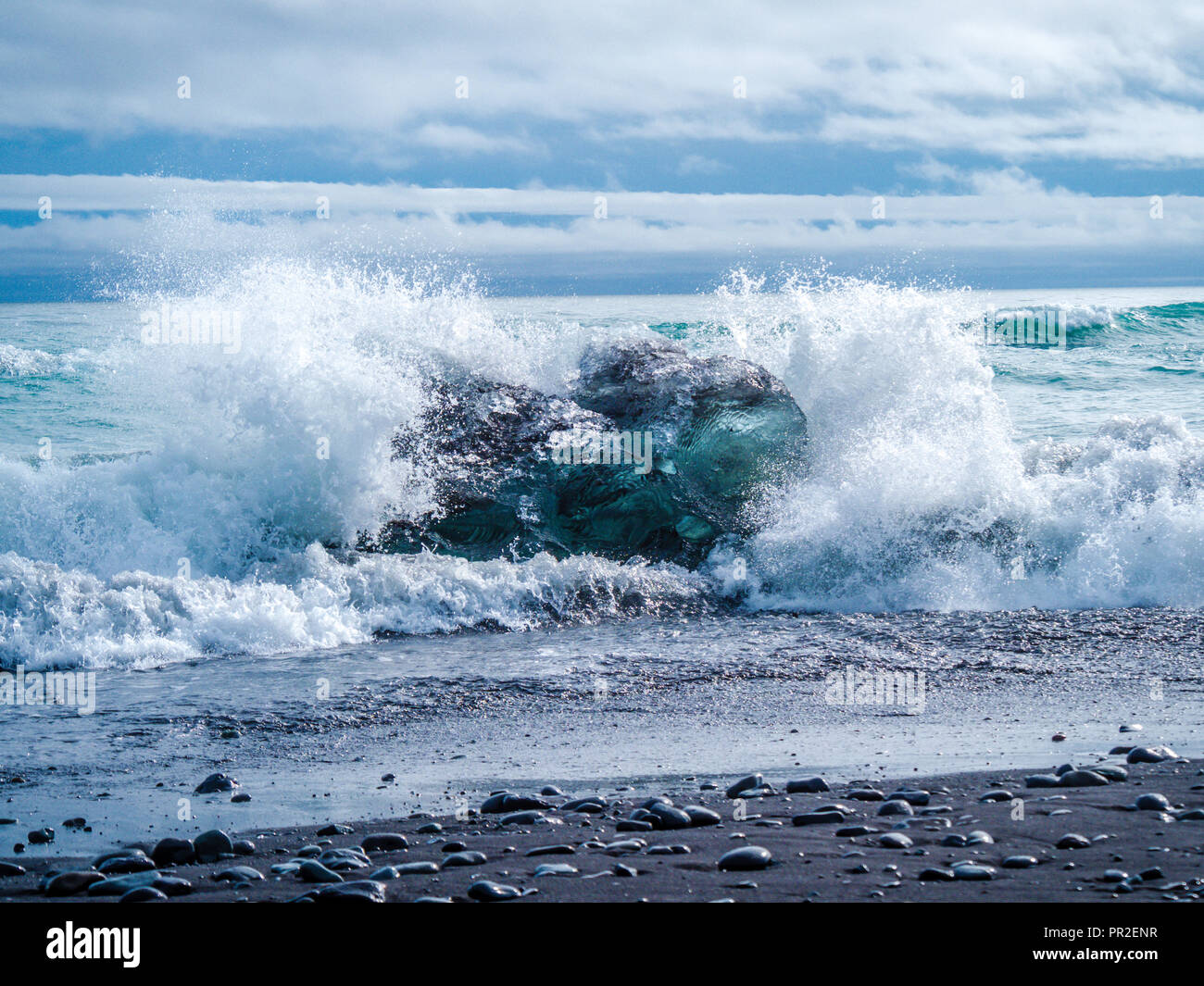 Ocean wave clashing at an iceberg on Diamond Beach in Iceland Stock ...
