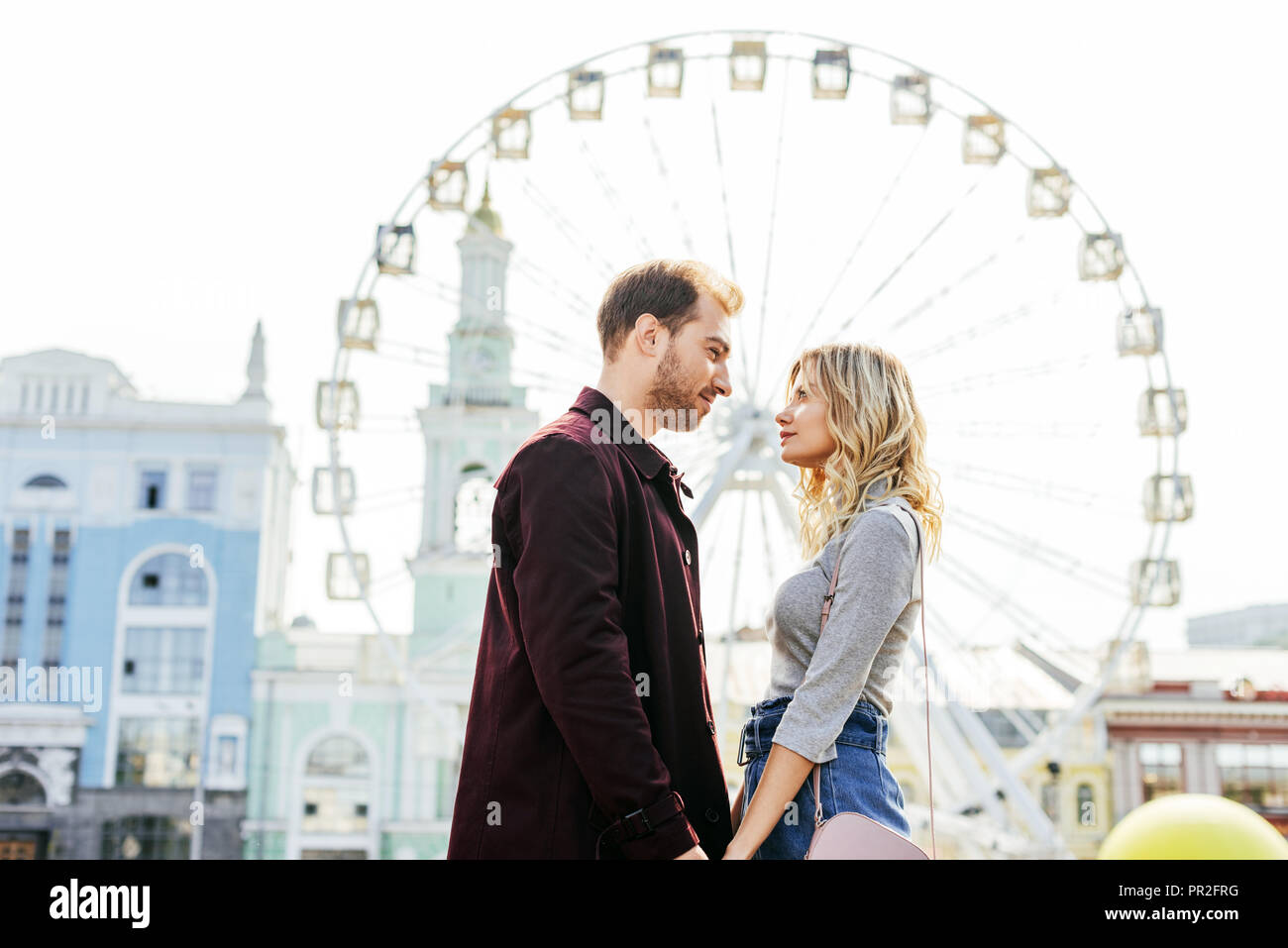 side view of couple in autumn outfit holding hands with observation ...