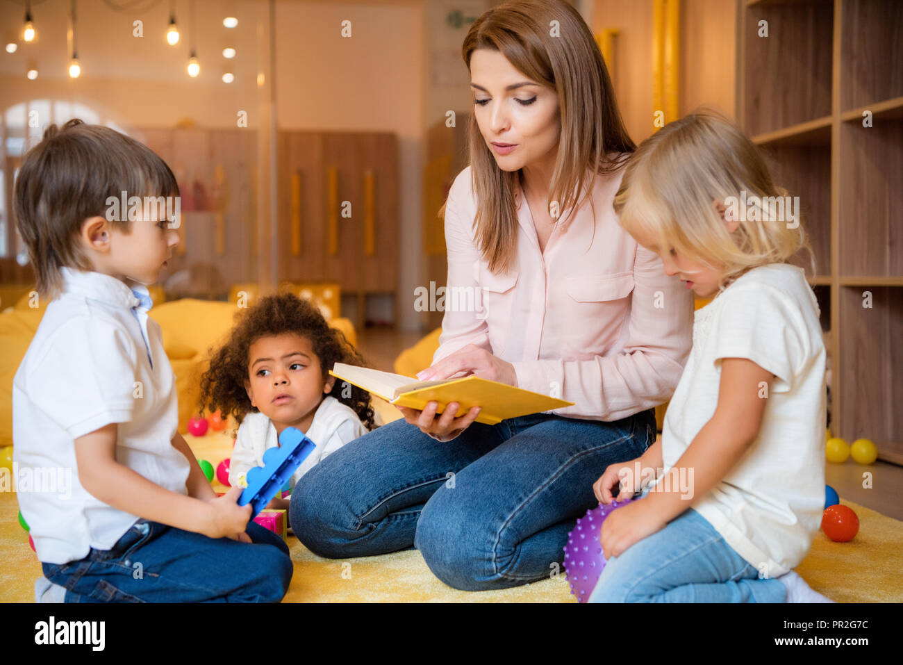 Group of preschoolers reading book hi-res stock photography and images ...