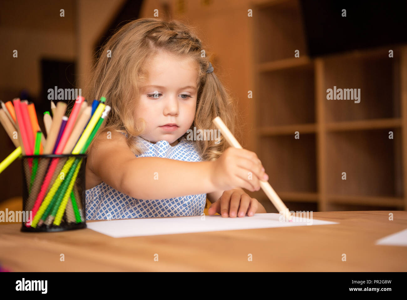 adorable child drawing in kindergarten, pen holder with colored felt ...