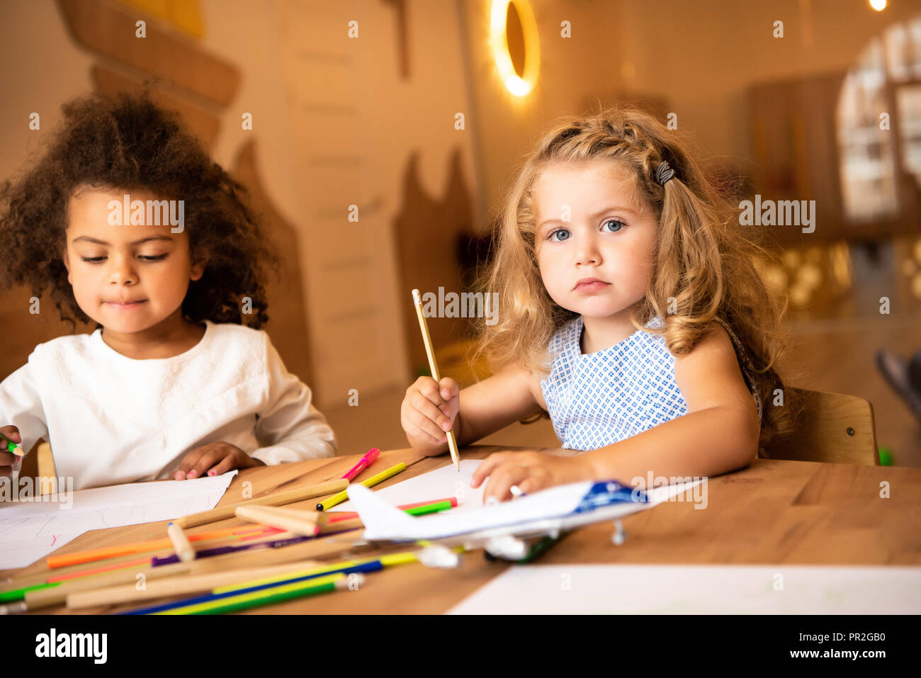 multicultural kids drawing with pencils in kindergarten Stock Photo - Alamy