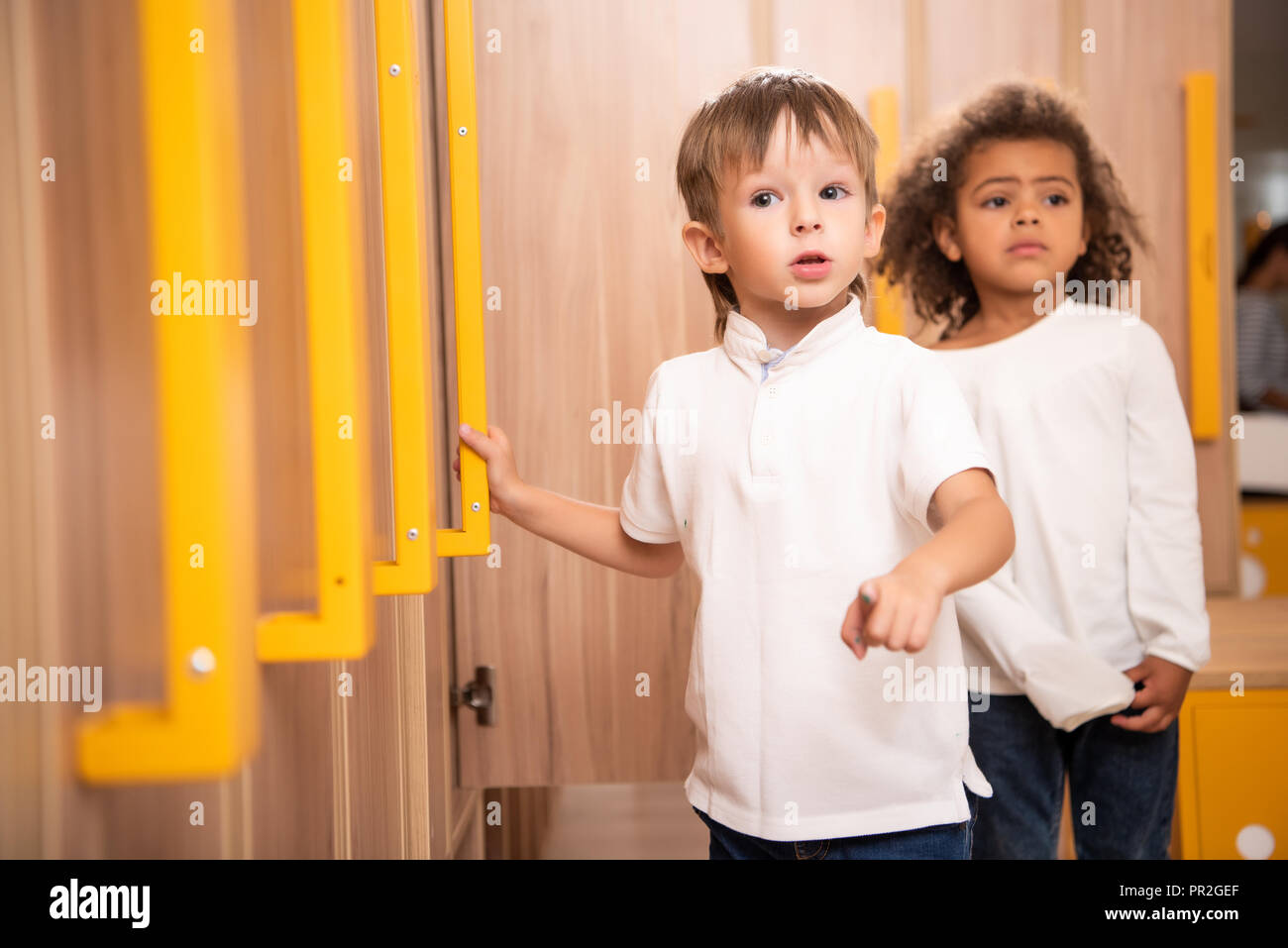 multiethnic kids standing in kindergarten cloakroom Stock Photo - Alamy
