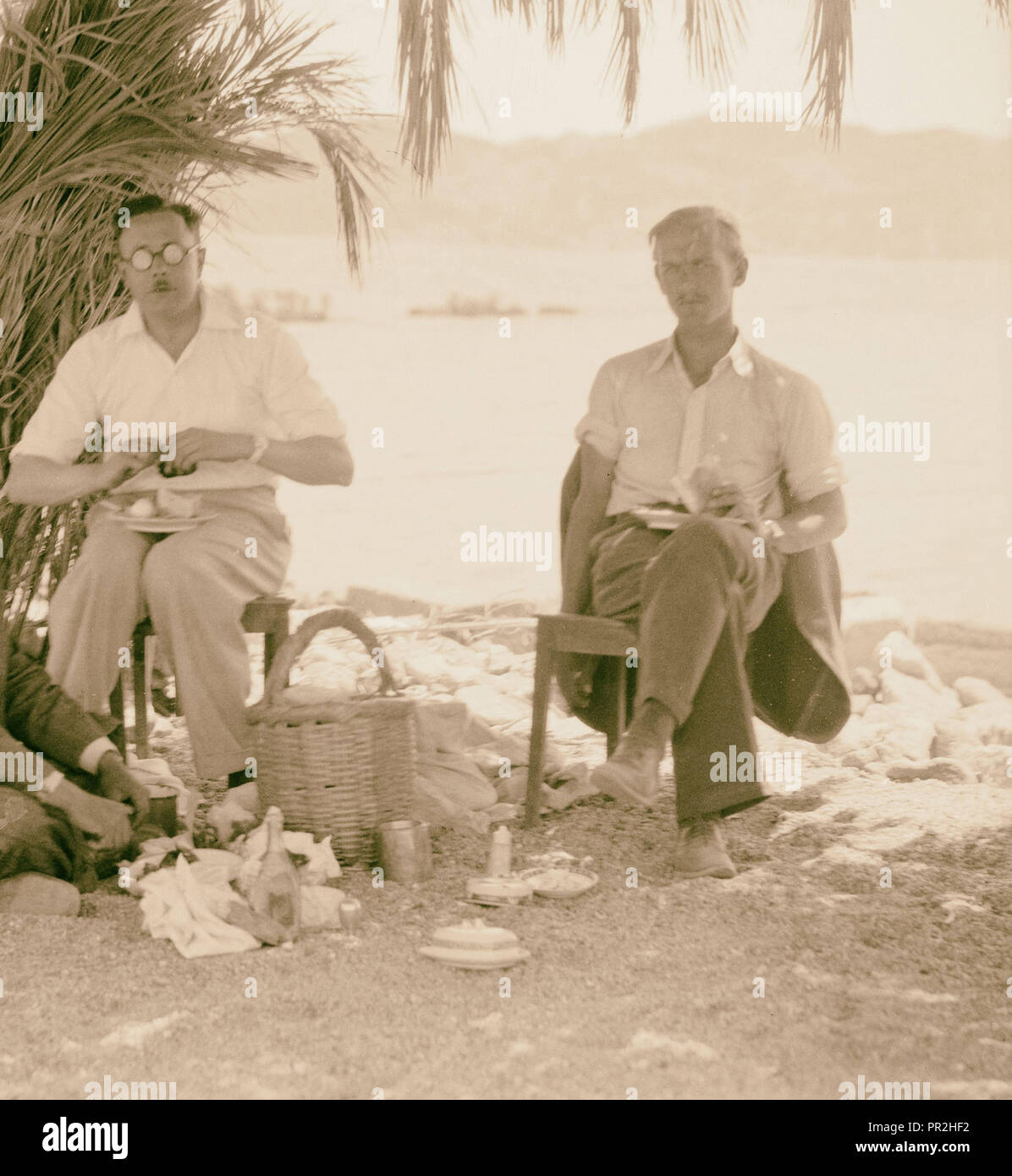 Camp at Petra. Photograh shows David Whiting with two other men, eating ...