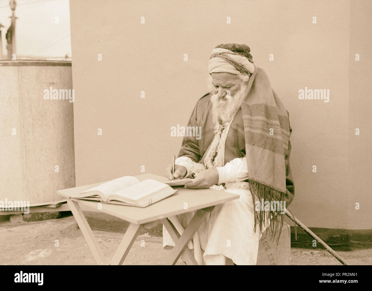 Abram with book in hand, writing. Photo shows Abram Ajwar, a Yemenite ...