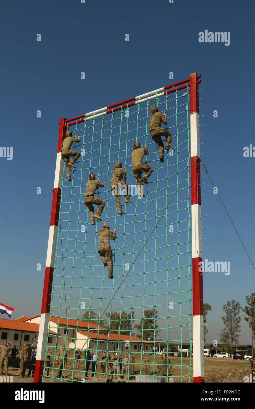 U.S. competitors climb a cargo net during the obstacle course event ...