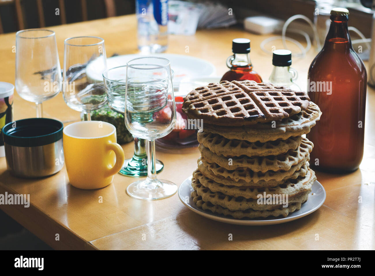 Waffles and maple syrup set on a dining table for a community late ...