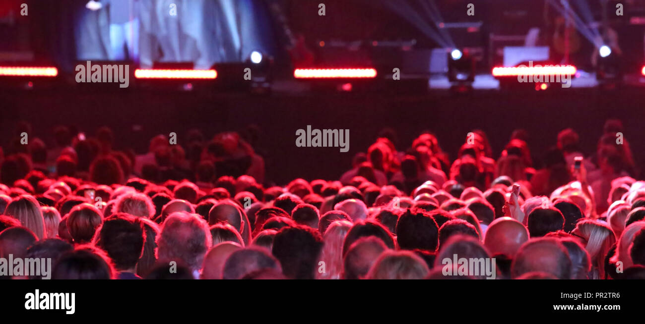 heads of many people during live outdoor concert with many lights on ...