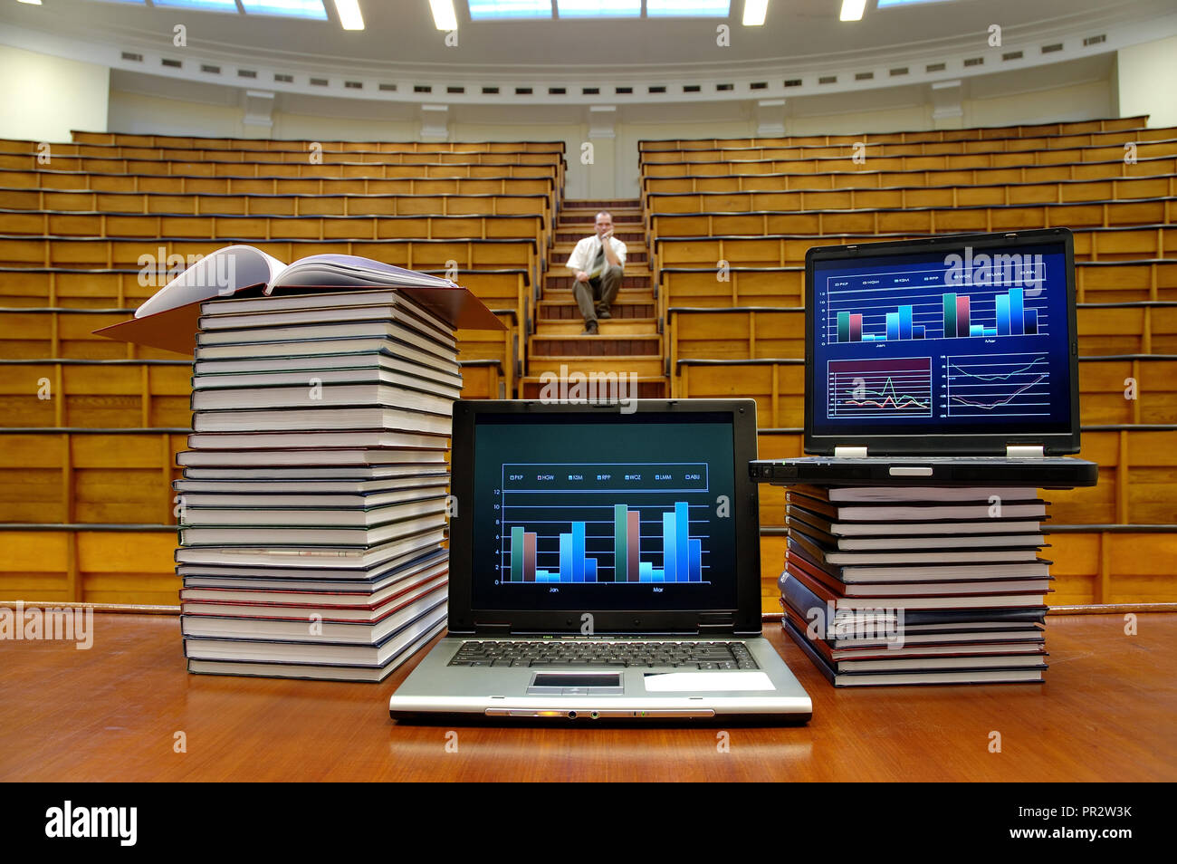 Academic teacher with computer and books in lecture hall Stock Photo ...